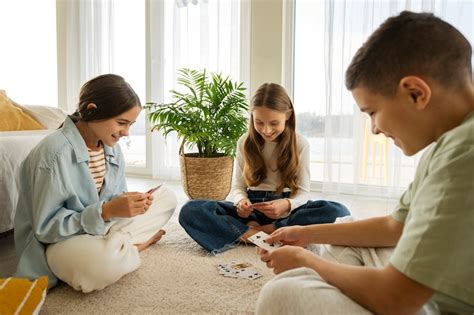 Free Photo Cousins Spending Time Together At Home And Playing Cards