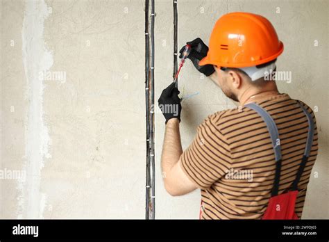 Male Electrician Hands Checks Presence Of Electrical Voltage In Socket Phase Uses Electrical