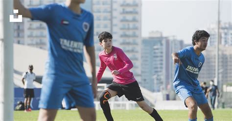 파란색과 흰색 축구 저지 셔츠와 검은 반바지를 입은 남자가 푸른 잔디 필드에서 뛰고 있다 사진 Unsplash의 무료 두바이 아랍에미리트 이미지