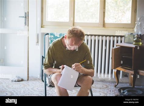 Man Writing Notes In Room Stock Photo Alamy