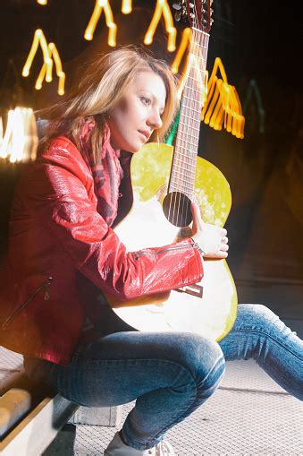 청소년 라이프 스타일 아이디어 및 개념 백인 금발의 여자 는 밤에 야외에서 기타를 연주 플래시와 할로겐 빛의 혼합물 세로 이미지 가죽에 대한 스톡 사진 및 기타 이미지