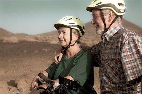 노란 헬멧을 쓰고 웃고 있는 두 명의 선배가 자전거로 하이킹을 즐기고 있다 건조한 열대 풍경입니다 활동 및 웰빙 개념 2명에 대한 스톡 사진 및 기타 이미지 Istock