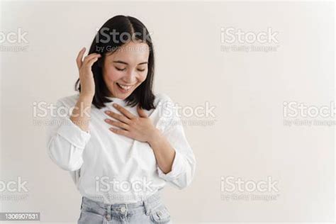 흰색 벽에 포즈를 취하는 미소 아름다운 갈색 머리 젊은 여성은 빈 벽에 참석 부끄러워 25 29세에 대한 스톡 사진 및 기타 이미지 25 29세 갈색 머리 감정