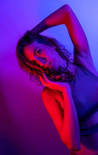 스튜디오에서 포즈를 취하는 컬러풀한 밝은 네온 블루와 보라색 조명을 입은 하이 패션 모델 여성 트렌디 한 빛나는 메이크업과 아름다운 소녀의 초상화 아트 디자인 생생한 스타일