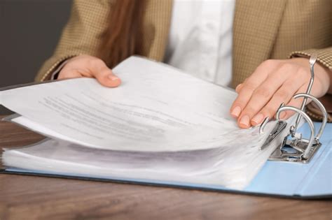 Premium Photo Businesswoman Putting Document Into File Folder At Wooden Table In Office Closeup