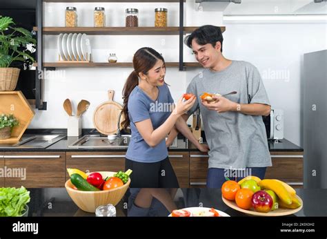 Asian Couple Spend Time Together In The Kitchen Young Woman Eating