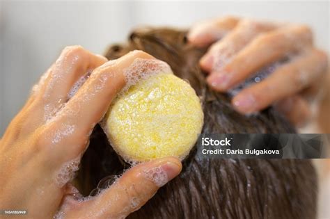 한 남자가 머리카락에 단단한 샴푸 바를 바릅니다 화장실에 있는 남자 지속 가능한 헤어 케어 친환경 화장품 플라스틱 프리 제로 폐기물 생활 낮은 물 재료 자연에 대한 책임