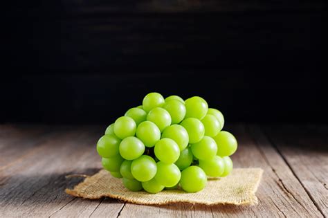 녹색 포도 건강을위한 신선한 과일 나무 테이블에 놓인 제철 과일 나무 배경에 달콤하고 육즙이 많은 포도 무리 검은 색과 어두운 오래 된 나무 배경 포도에 대한 스톡 사진 및