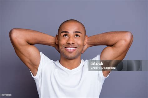 브런치에 뒤에 그의 사나이 대머리 머리 팔 단순히 보면 그 별 입고 흰색 T셔츠 옷 옷 절연 회색 배경 그 사진 진정 강한 건강 한 남성 어두운 피부를 닫습니다 T 셔츠에