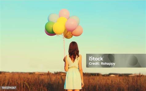 여름 밀짚모자를 쓰고 화려한 풍선을 잔뜩 쓴 젊은 여성의 뒷모습 야외에서 드레스를 입고 있다 25 29세에 대한 스톡 사진 및 기타 이미지 Istock