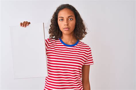 젊은 브라질 여성은 심각한 생각 스마트 얼굴에 자신감 표정으로 고립 된 흰색 배경 위에 서 배너를 들고 감정에 대한 스톡 사진 및 기타 이미지 Istock