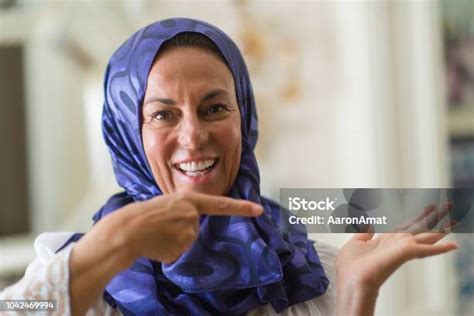 다채로운 Hijab 손과 손가락으로 가리키는 매우 행복을 착용 해 중간 나이 갈색 아라비아 여자 가리키기에 대한 스톡 사진 및 기타 이미지 Istock