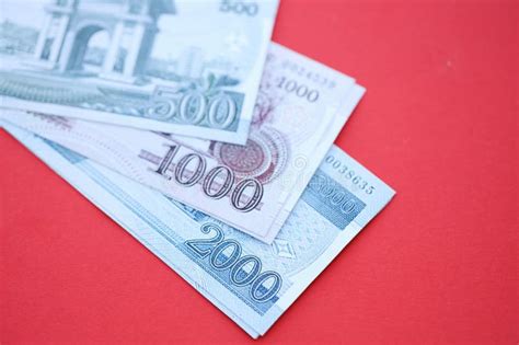north korean won money bills in big amount lies on red color table