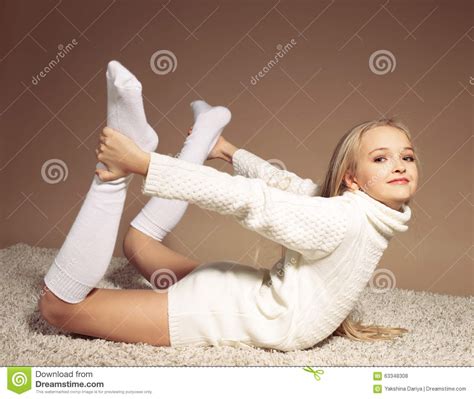 Красивая маленькая девочка с длинными светлыми волосами в уютных связанных одеждах Стоковое Фото