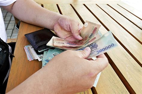 유토이미지 여행 중에 베트남 돈을 계산 하는 관광객