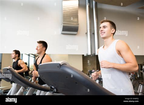 Smiling Men Exercising On Treadmill In Gym Stock Photo Alamy