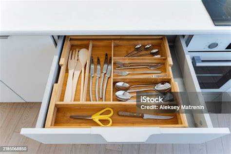 부엌 서랍은 다양한 식기와 가위로 깔끔하게 정리되어 있으며 나무 금속 직사각형 모양이 혼합되어 재료의 조화로운 조합을 만듭니다 0명에 대한 스톡 사진 및 기타 이미지