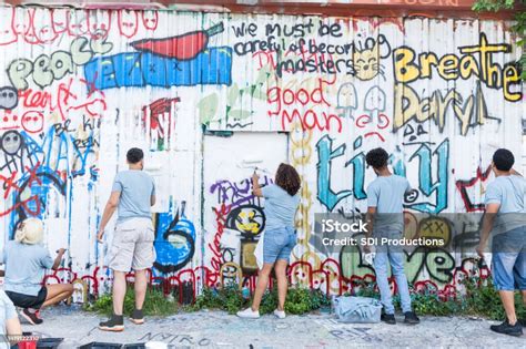 이웃의 낙서를 통해 그림을 그리는 다양한 자원 봉사자 후면보기 그래피티에 대한 스톡 사진 및 기타 이미지 그래피티 그림 그리기 벽화 Istock