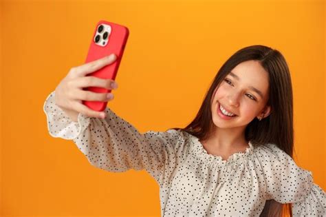 Premium Photo Teen Girl Making A Selfie On Her Phone Against Yellow