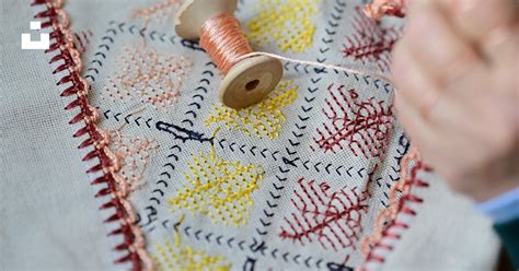 한 사람이 테이블 위에 천 조각을 꿰매고 있습니다 사진 Unsplash의 무료 무늬 이미지