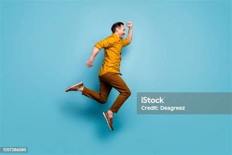 풀 사이즈 프로필 사이드 사진 의 쾌활 한 긍정적 인 남자 점프 실행 봄 시간 판매 착용 캐주얼 스타일 의상 운동화 위에 고립 된 블루 컬러 배경 남자에 대한 스톡 사진 및