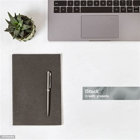 현대 교육 개념 학생을위한 작업 공간 작업 공간 회색 컴퓨터 작은 즙이 많은 빈 노트북과 테이블에 펜 맨 위 보기 플랫 레이