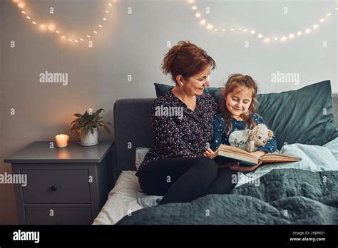 Mother Reading Book Her Daughter In Bed Before Going To Sleep Reading