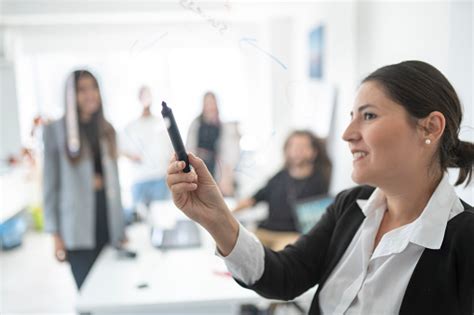 비즈니스 여성은 사무실 회의실에서 열린 컨퍼런스 미팅에서 마커 펜으로 유리 보드에 글을 쓰고 있습니다 유리 재료에 대한 스톡