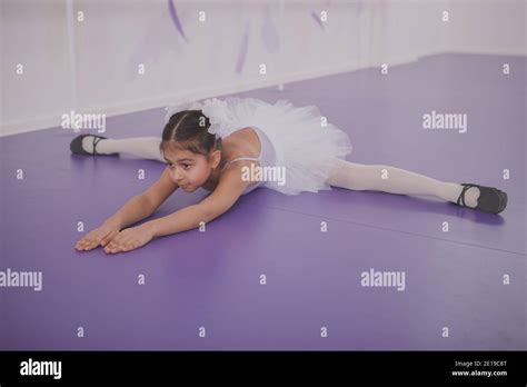 Adorable Little Ballerina Stretching Before Ballet Class At Dance