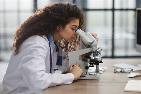 Premium Photo Attractive Female Scientist Looking Through A Microscope