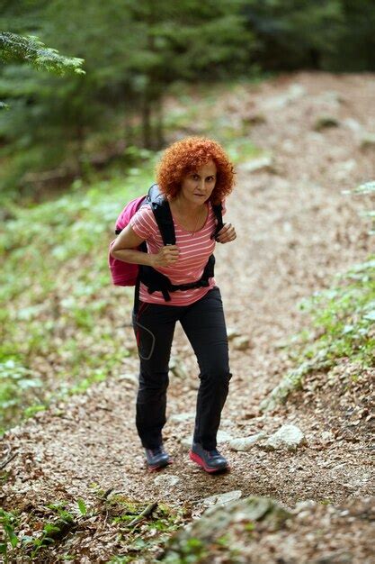 Premium Photo Curly Redhead Woman Hiking On A Trail In The Mountains