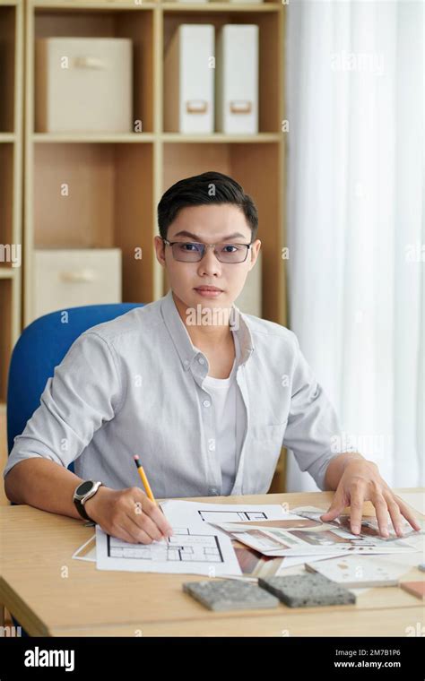 Portrait Of Interior Designer Working On Apartment Plan And Collecting Samples And Photos To