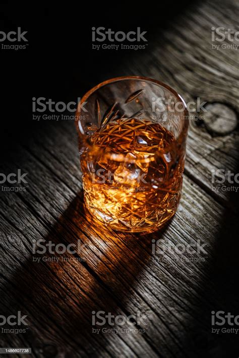 소박한 나무 테이블 위의 유리잔에 얼음이나 브랜디를 곁들인 위스키 유리잔에 얼음을 넣은 위스키 유리에 위스키 또는 코냑 선택적