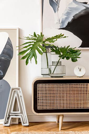 세련된 Commode 시계 추상 회화 열대 잎 큰 편지와 우아한 액세서리와 멋진 스칸디나비아 아파트에서 거실의 인테리어 디자인 현대적인 홈 장식 템플릿 0명에 대한 스톡