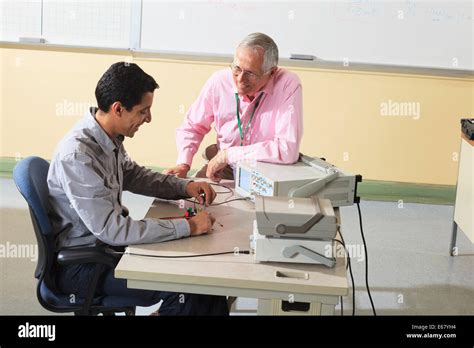 Engineering Babe Discussing Oscilloscope Measurements With Professor For An Electronics Lab