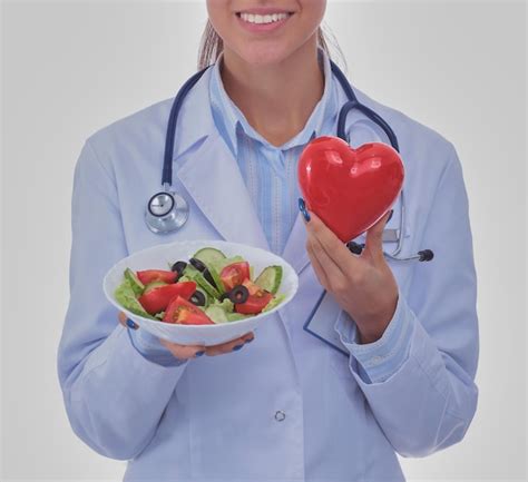 Premium Photo Portrait Of A Beautiful Woman Doctor Holding A Plate With Fresh Vegetables And