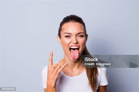 클로즈업 사진 아름 다운 놀라운 그녀는 그녀의 여자 이상적인 외모 혀 밖으로 입에 공 손 한 사람 뿔 기호 손가락 바위 전설