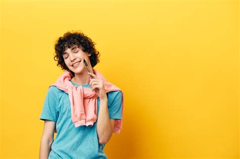 손에 연필을 든 곱슬곱슬한 남자는 고립된 배경을 생각했다 프리미엄 사진