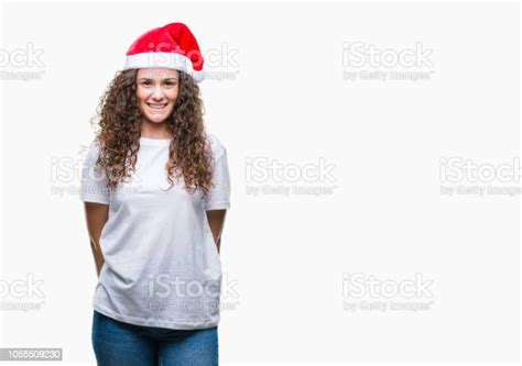 젊은 갈색 머리 소녀 얼굴에 행복 하 고 멋진 미소와 함께 고립 된 배경 위에 크리스마스 모자를 쓰고 운이 좋은 사람 갈색
