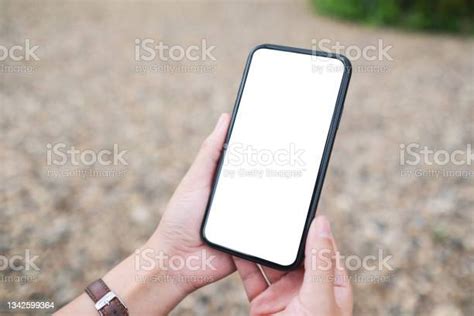 야외에서 빈 흰색 데스크톱 화면으로 휴대 전화를 들고있는 여성의 모형 이미지 Brand Name Smart Phone에 대한 스톡 사진 및 기타 이미지 Brand