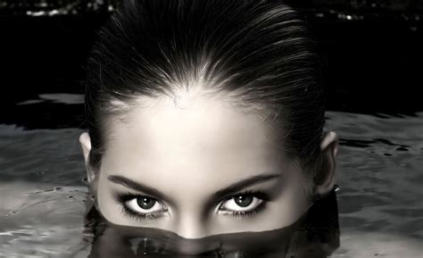 Обои на рабочий стол Девушка плывет в воде выставив наружу только часть лица с открытыми глазами