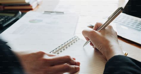 사업가는 사무실에서 비즈니스 재무 분석을 위해 메모장에 메모를 남깁니다 사진 Unsplash의 문서 이미지