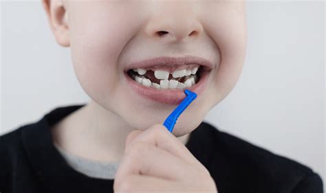 치간 브러시 금발 소년이 치간 공간을 청소하기위한 브러시를 보여줍니다 치아 청소 및 매일 구강 관리를위한 브러시 치과 및 교정 아이에 대한 스톡 사진 및 기타 이미지