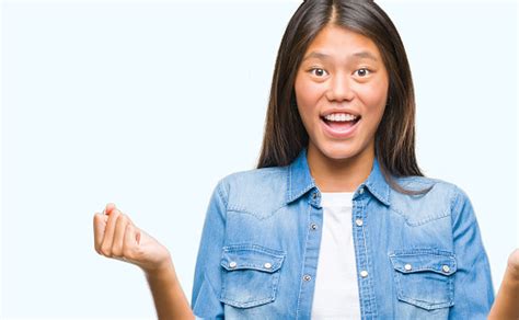 격리 된 배경 축 하에 젊은 아시아 여자 놀라게 하 팔 제기 성공을 위한 놀라게 했 고 눈 우승자 개념입니다 긍정적인 감정 표현에 대한 스톡 사진 및 기타 이미지 Istock