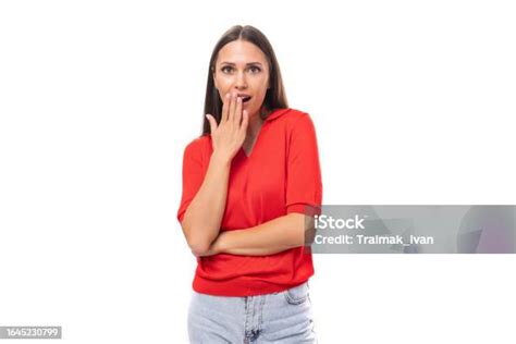 빨간 티셔츠를 입은 검은색 스트레이트 머리를 한 젊은 백인 여성 모델은 복사 공간이 있는 흰색 배경에 놀란 것처럼 보인다 25 29세에 대한 스톡 사진 및 기타 이미지