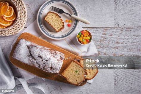 테이블에 수건과 포크가 달린 나무 판에 누워 말린 오렌지와 함께 조각으로 자른 가루 설탕을 곁들인 흰색 달콤한 빵 0명에 대한 스톡 사진 및 기타 이미지 Istock