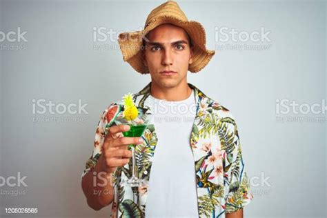 젊은 잘 생긴 남자 마시는 칵테일 에 휴가 위에 흰색 고립 된 배경 과 자신감 표정 에 스마트 얼굴 생각 심각한 남자에 대한 스톡 사진 및 기타 이미지 Istock