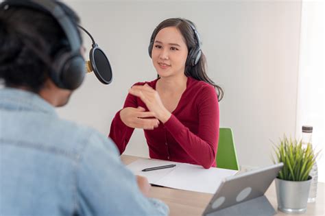 스튜디오에서 아시아 라디오 호스트 팟 캐스트 남성과 여성 화자는 컴퓨터의 마이크와 카메라를 통해 이야기합니다 아침에 산다 25