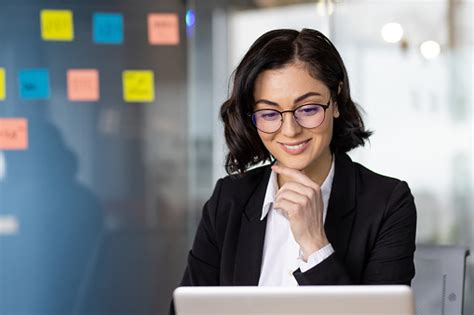 비즈니스 정장을 입고 노트북을 들고 일하는 성공한 사업가 직장에서 사무실 안에서 노트북 화면을 보며 만족스럽게 웃는 여성 상사 성취 결과에 만족하는 여성 직원 가상현실에