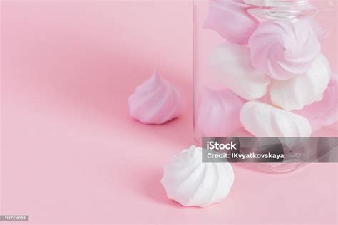 핑크 바탕에 유리 항아리에 흰색과 분홍색 트위스트 머 랭 설탕을 휘 핑 하 고 달걀 흰 자를 구워 만든 프렌치 디저트 복사